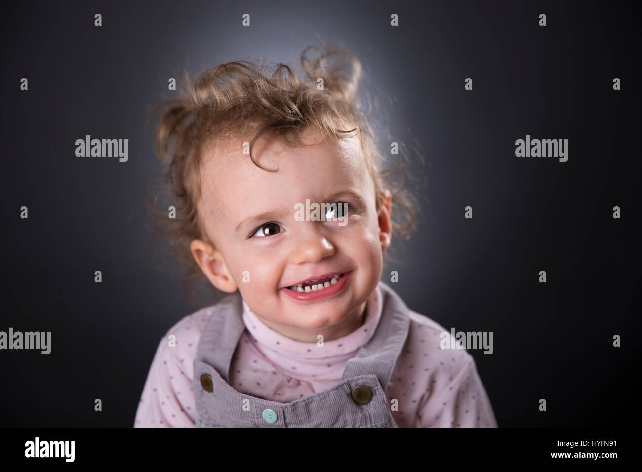 Portrait of a two years girl laughing. Studio shot. Black background ...