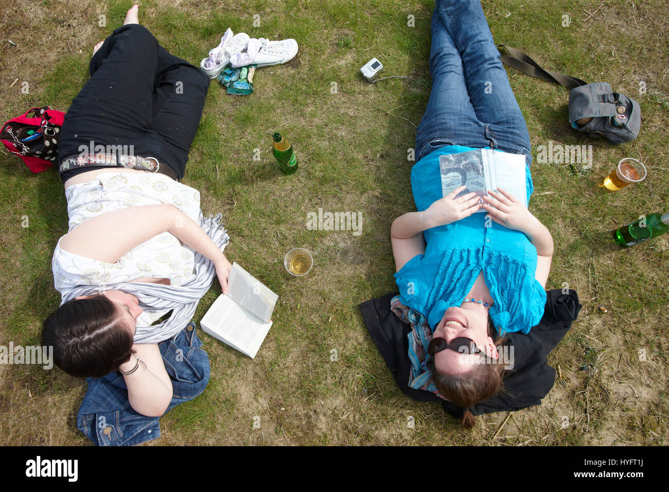Two people laying down on the grass relaxing. The Literary Festival ...