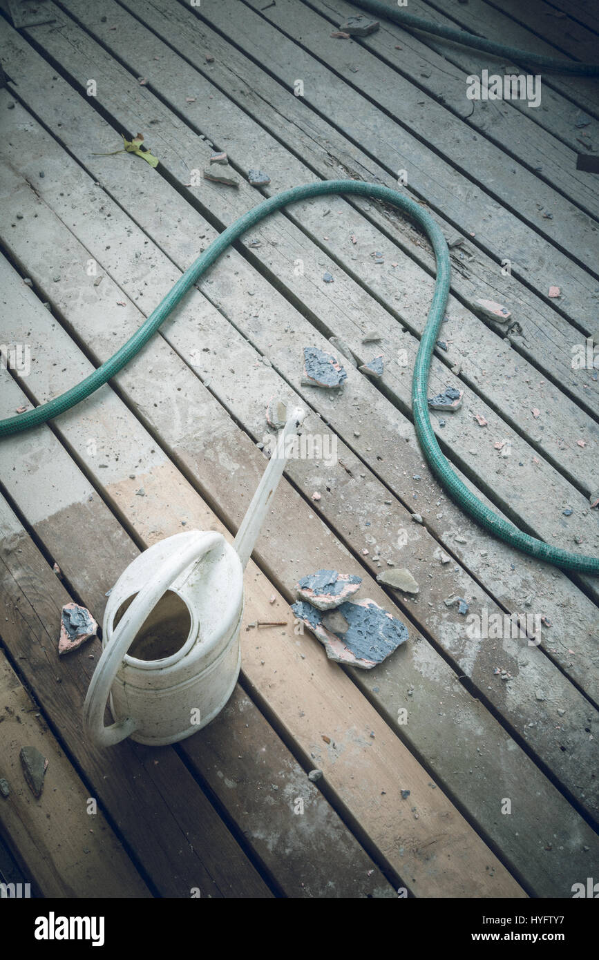 Watering can and a hose on a wooden deck when construction was ...