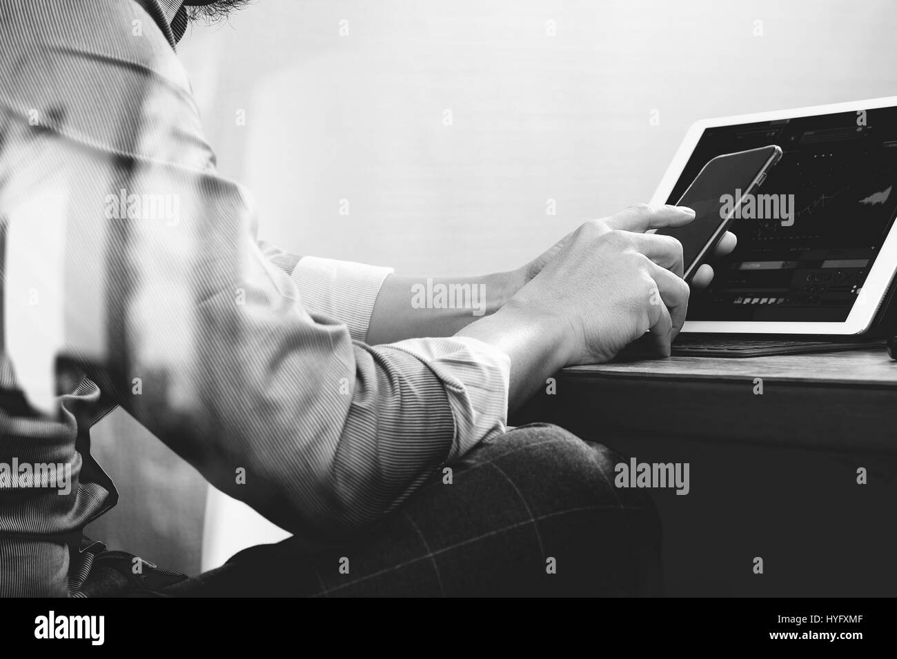 success businessman hand using smart phone,digital tablet docking smart keyboard on wood desk ...