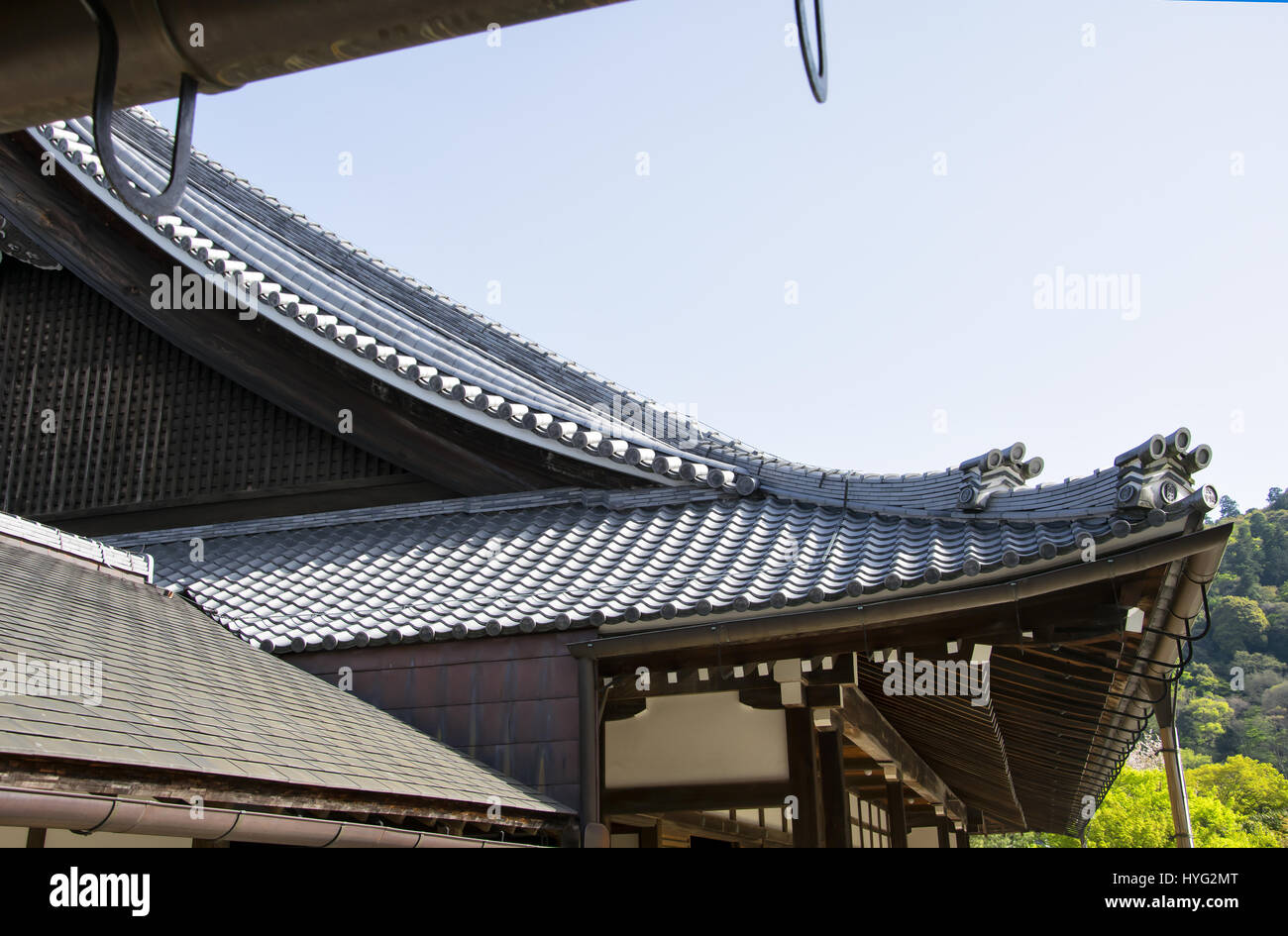 Detail on Japanese temple roof against blue sky during cherry blossom ...