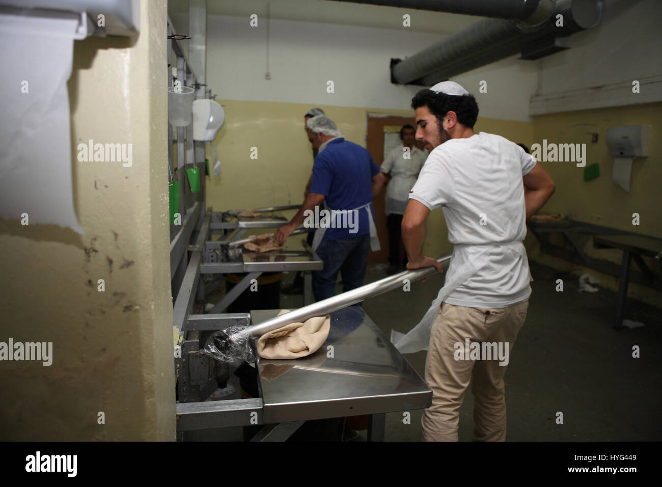 Religious Jewish men leap to gather power using sticks to knead dough ...