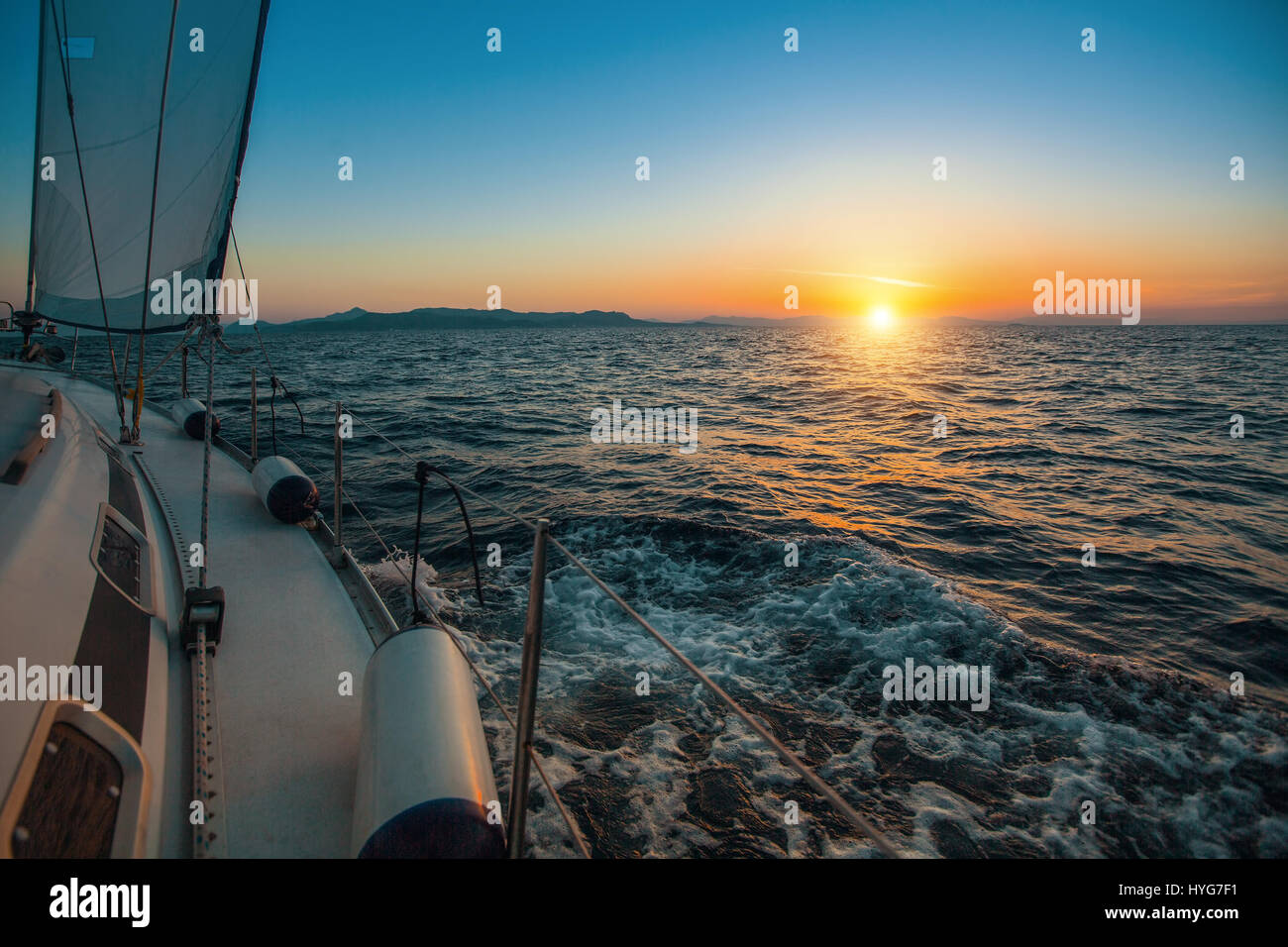 Sailboat with sails set to Sea at full speed at amazing sunset. Luxury ...