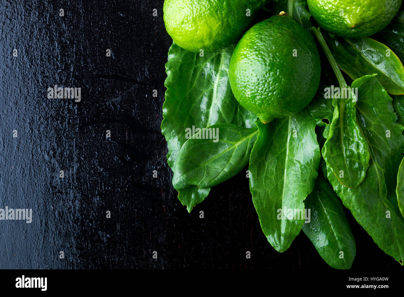 Wet spinach and lime on black background. Green fruit. Detox. Fresh ...