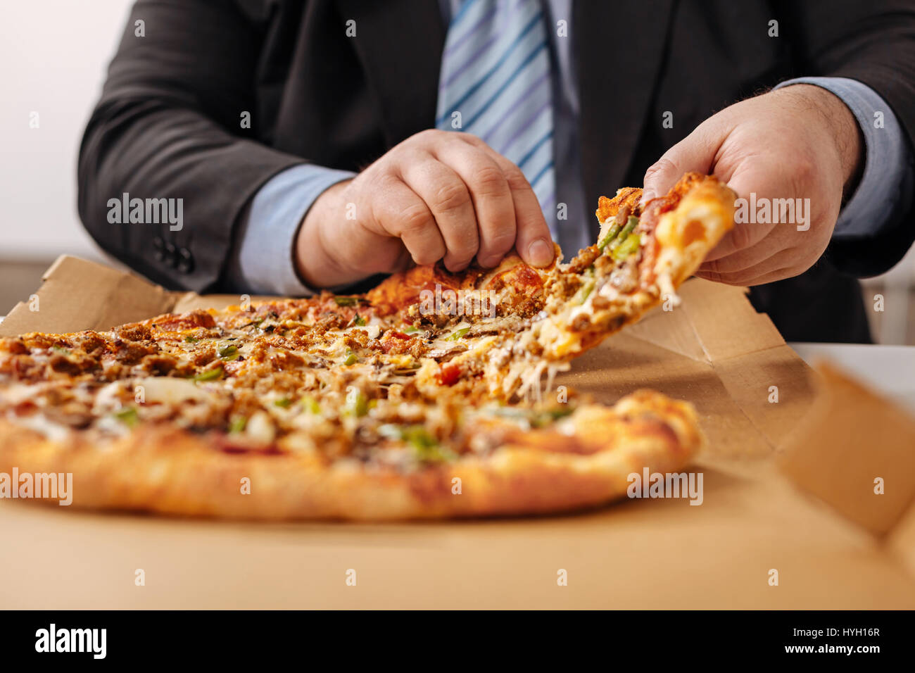 Frontline company employee eating pizza Stock Photo - Alamy