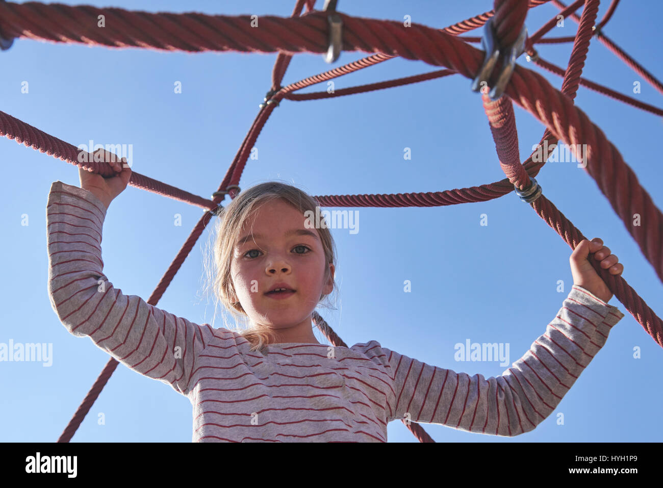 Active young child girl climbing the spider web playground activity ...