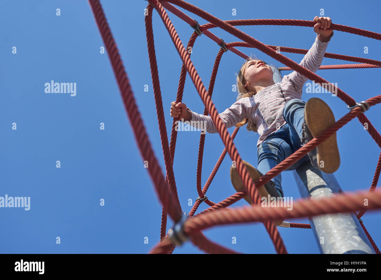Active young child girl climbing the spider web playground activity ...