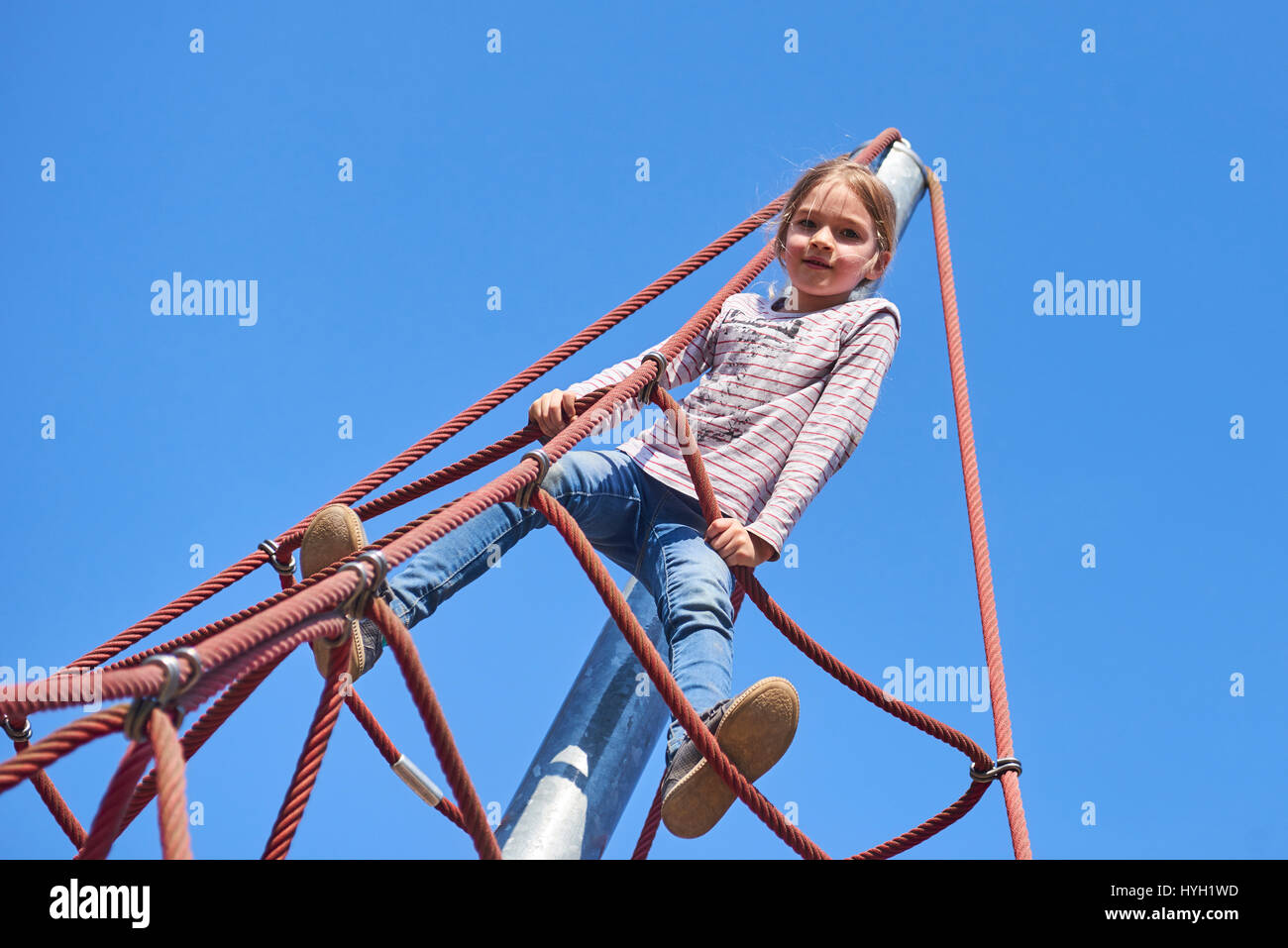 Active young child girl climbing the spider web playground activity ...