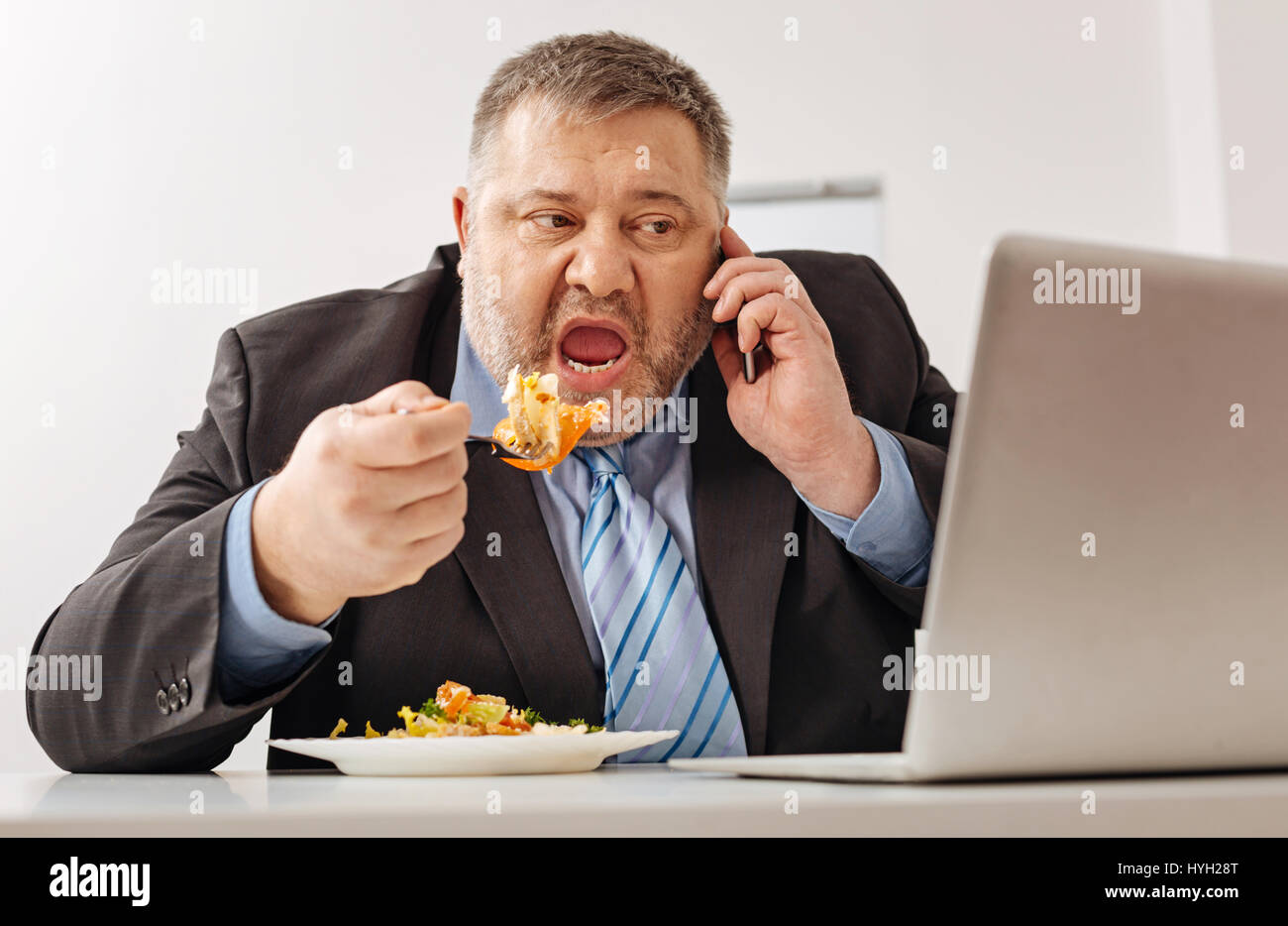 Hungry tired company employee overloaded with work Stock Photo - Alamy