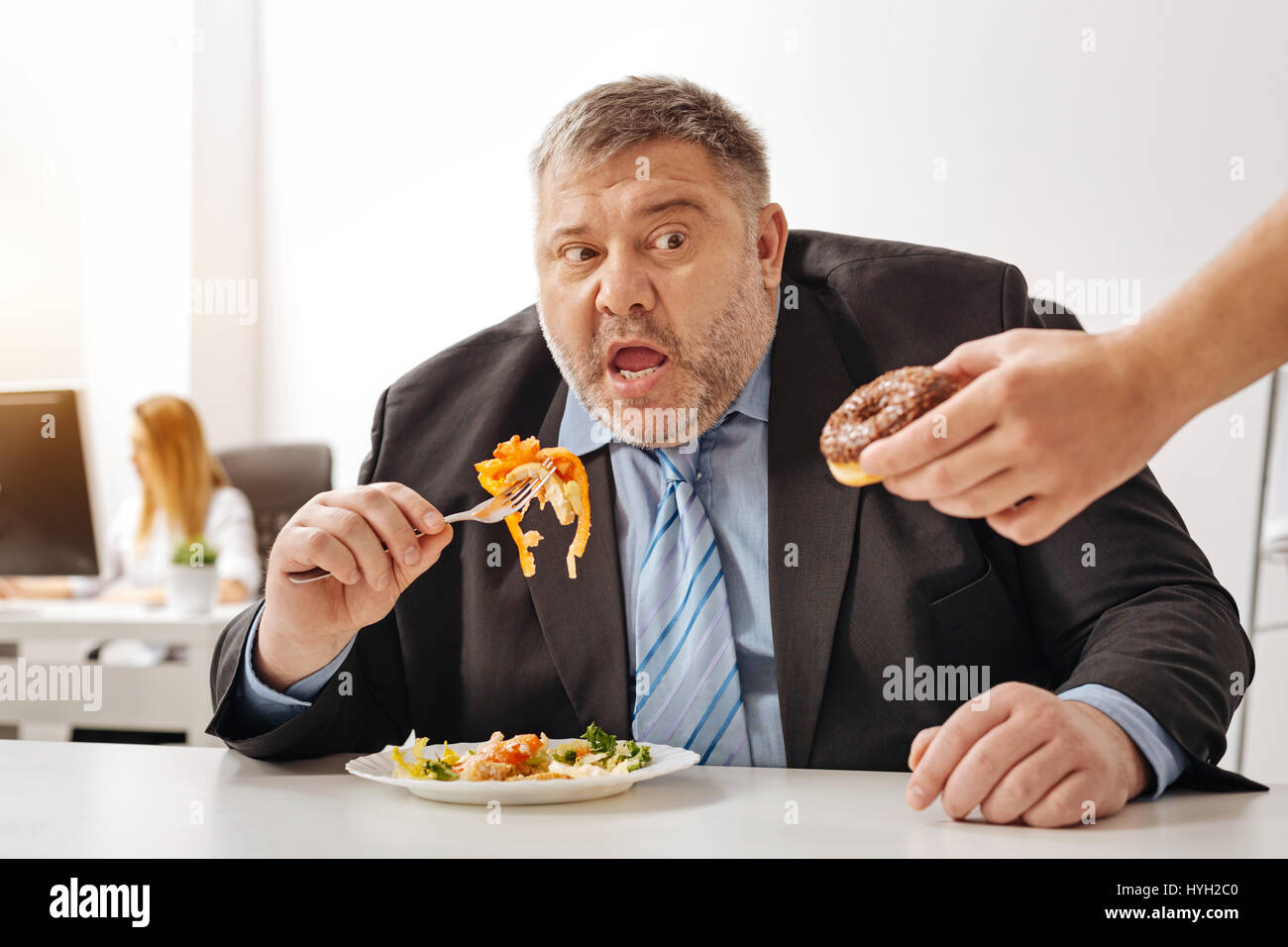 Comical puffy guy being seduced by junk food Stock Photo - Alamy