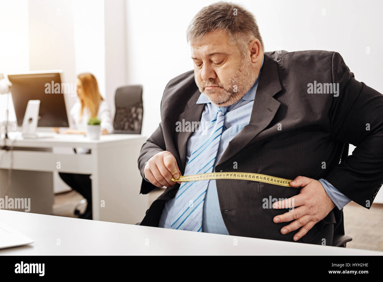 Hardworking employee suffering from excess weight Stock Photo - Alamy