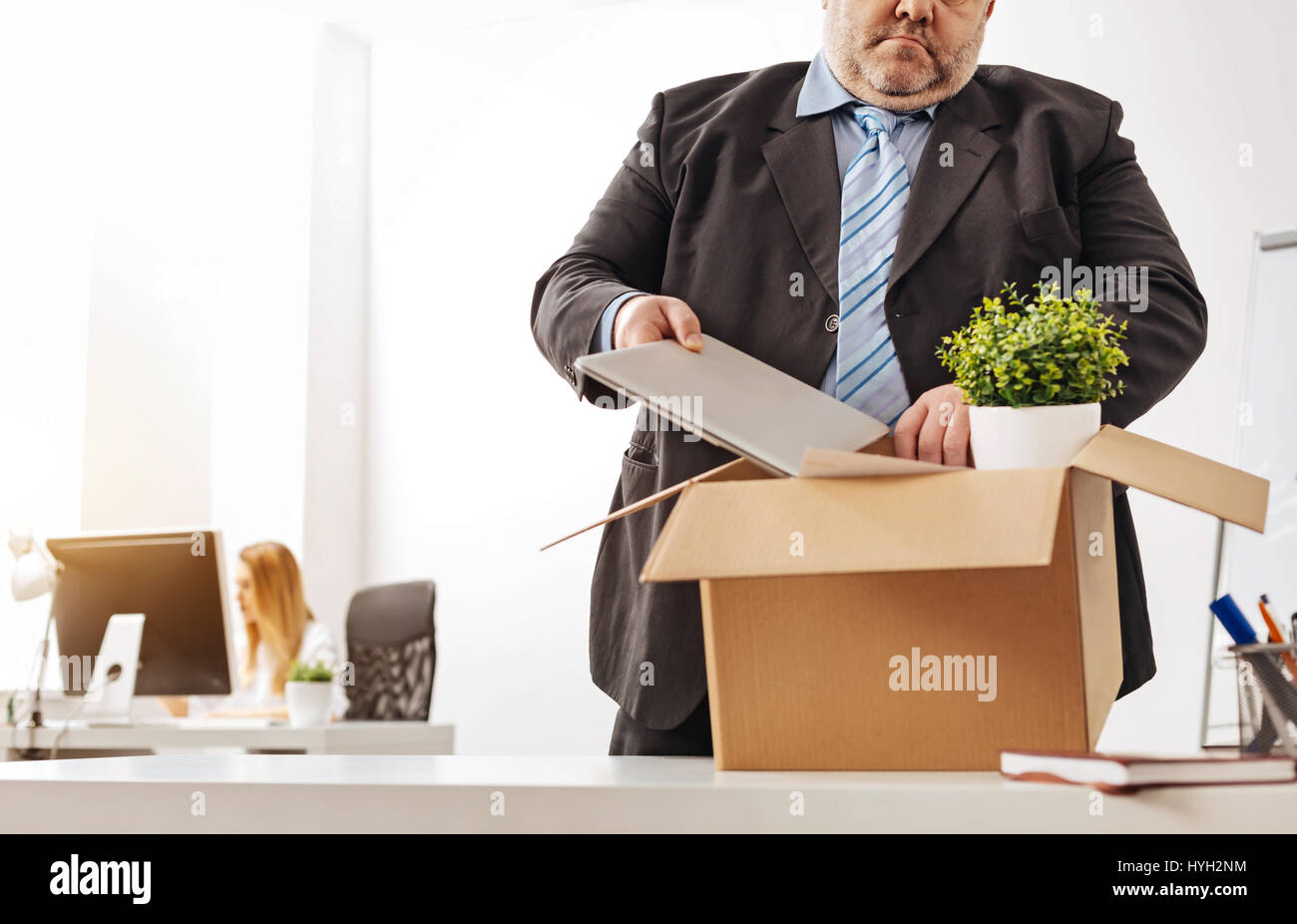 Anxious tired employee packing his things Stock Photo - Alamy