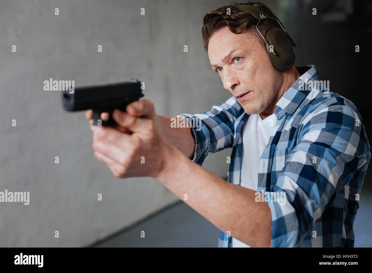 Nice serious man visiting the shooting range Stock Photo - Alamy