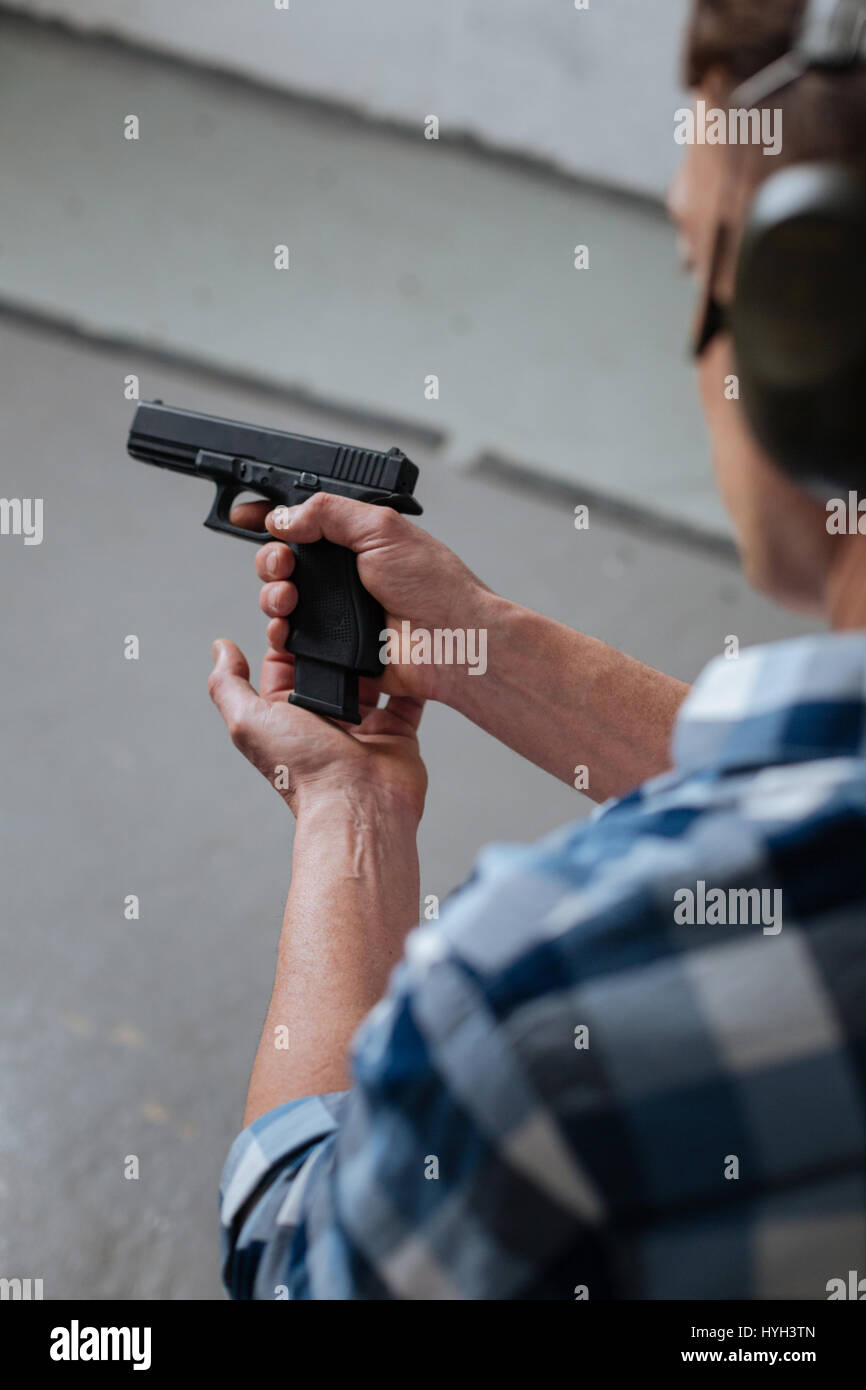 Brutal professional marksman reloading his gun Stock Photo - Alamy