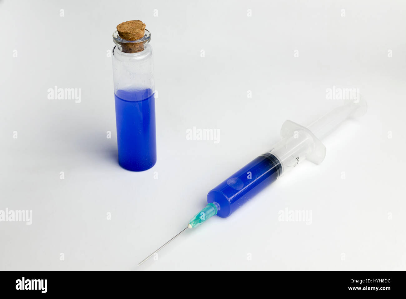 The flask and syringe with blue solution in laboratory research ...