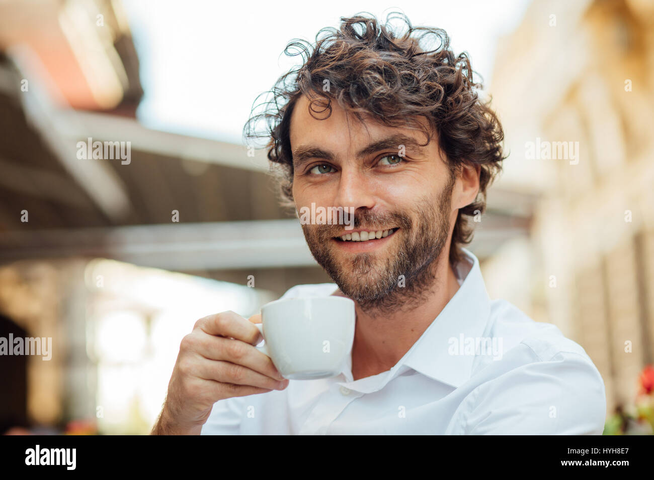 portrait of a young and masculine man drinking a coffee outside Stock ...
