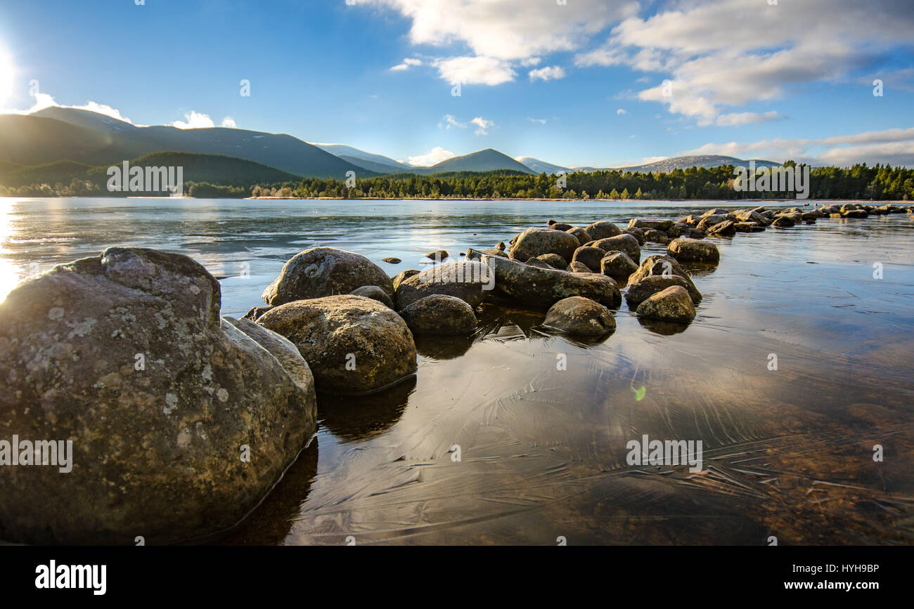Big rocks on a surface of frozen lake in Scottish Highlands with clouds ...