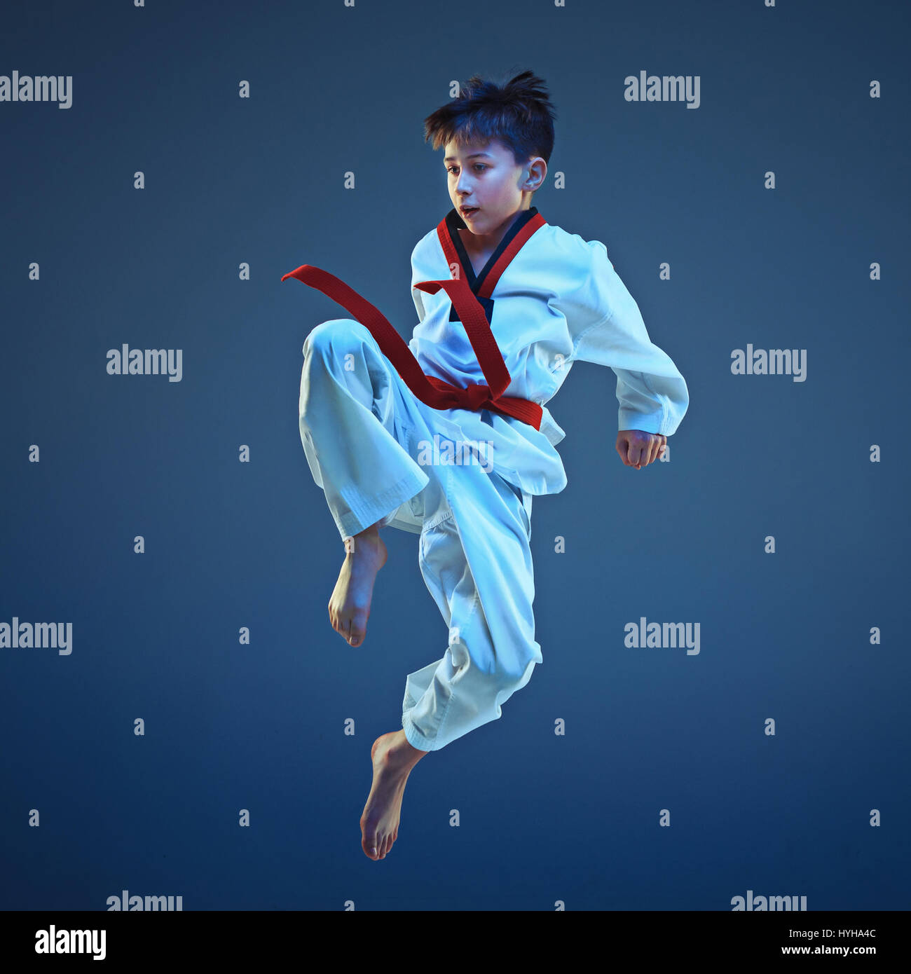 Young boy training karate on blue background Stock Photo - Alamy