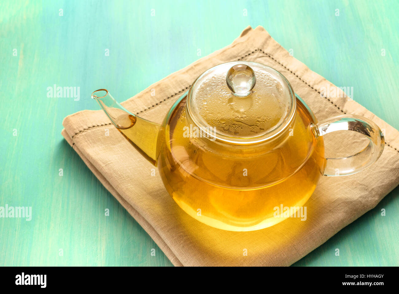 Teapot full of tea on teal texture with copyspace Stock Photo - Alamy
