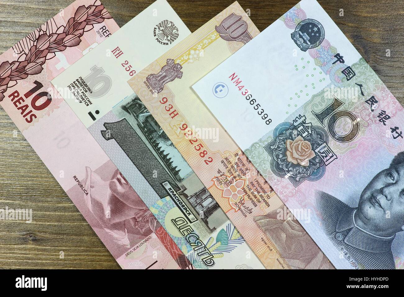 banknotes of the BRIC states on wooden background Stock Photo - Alamy