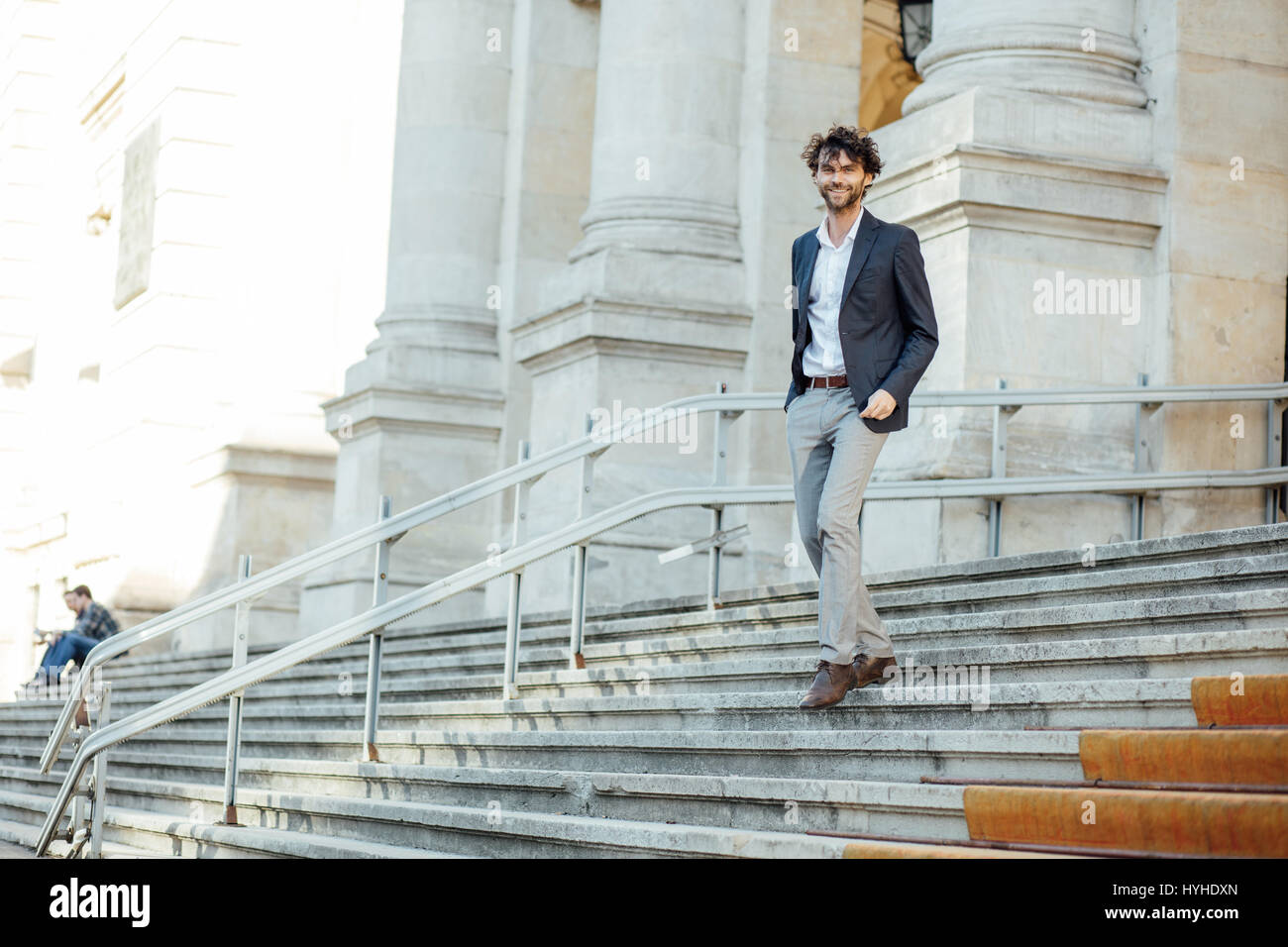 elegant and modern man walking down stairs of important building with ...