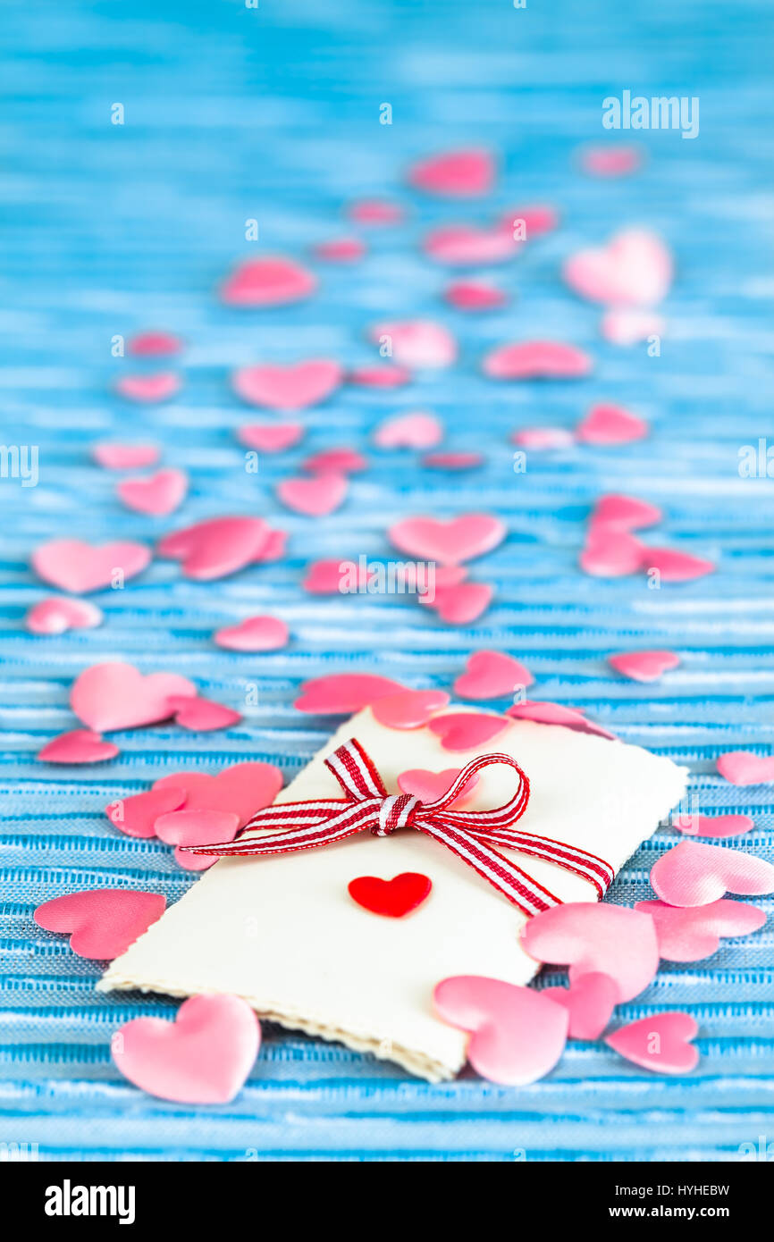 Nostalgic love letter with ribbon and many pink hearts around up to the ...