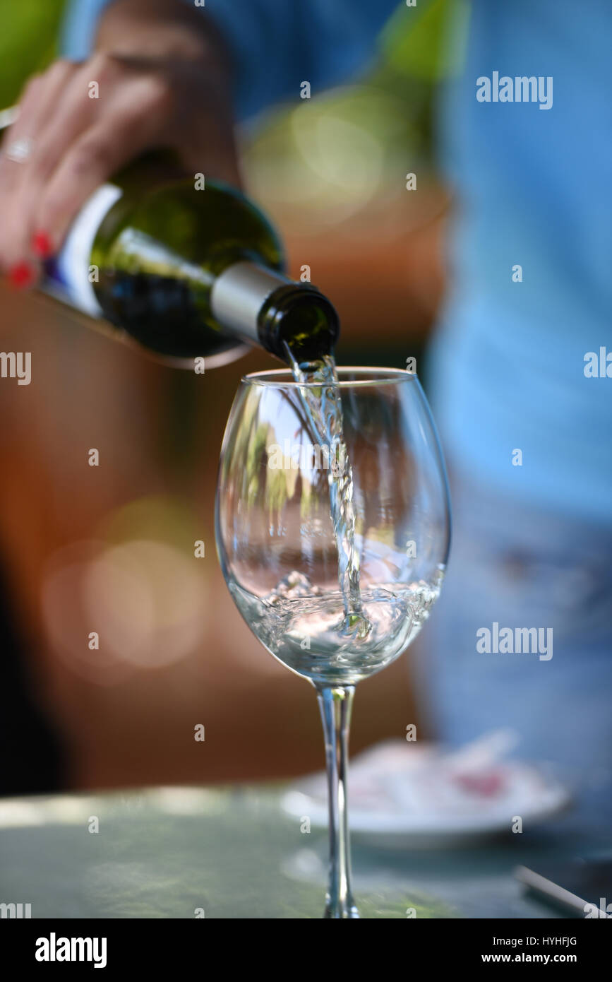 Hand pouring wine to a wine glass Stock Photo - Alamy