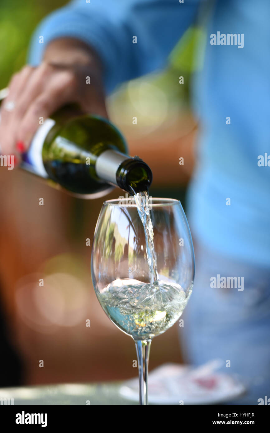 Hand pouring wine to a wine glass Stock Photo - Alamy