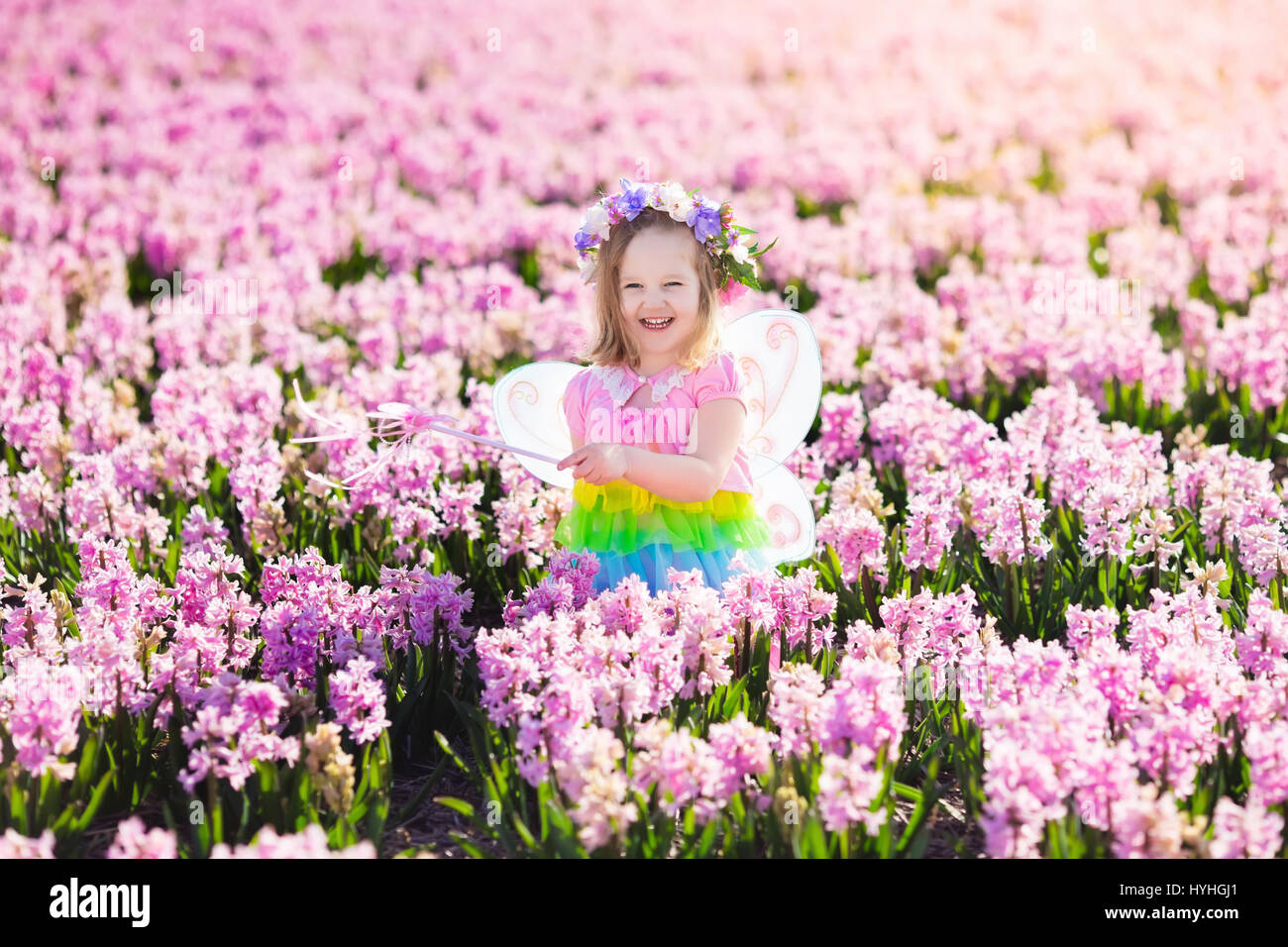 Beautiful girl playing in blooming hyacinth flower field. Kids princess ...