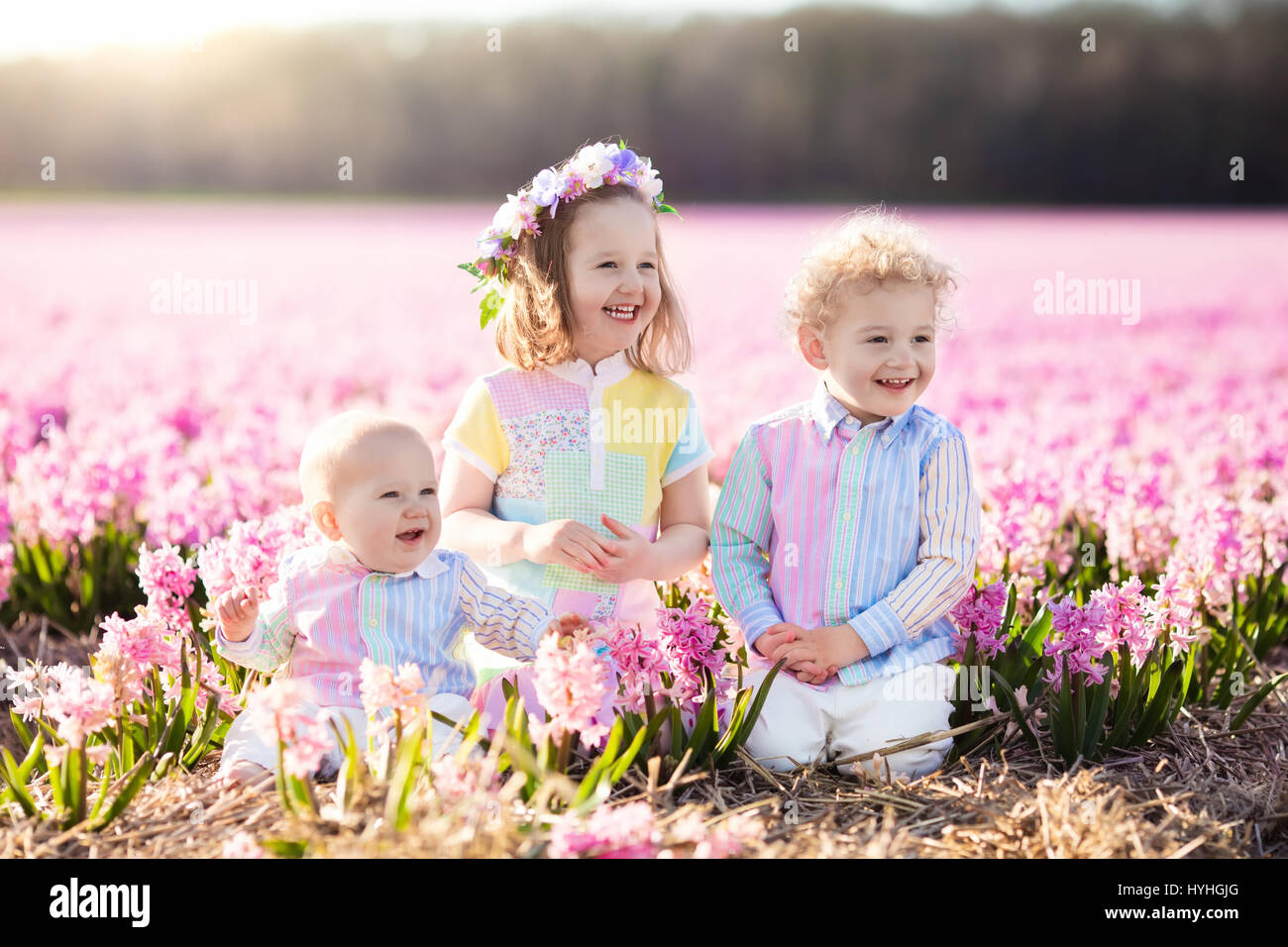 Three children playing in beautiful hyacinth flower field. Little girl ...
