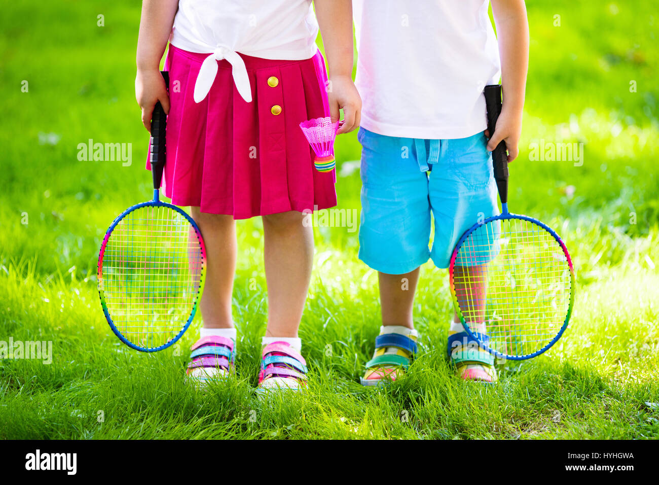 Active preschool girl and boy playing badminton in outdoor court in ...