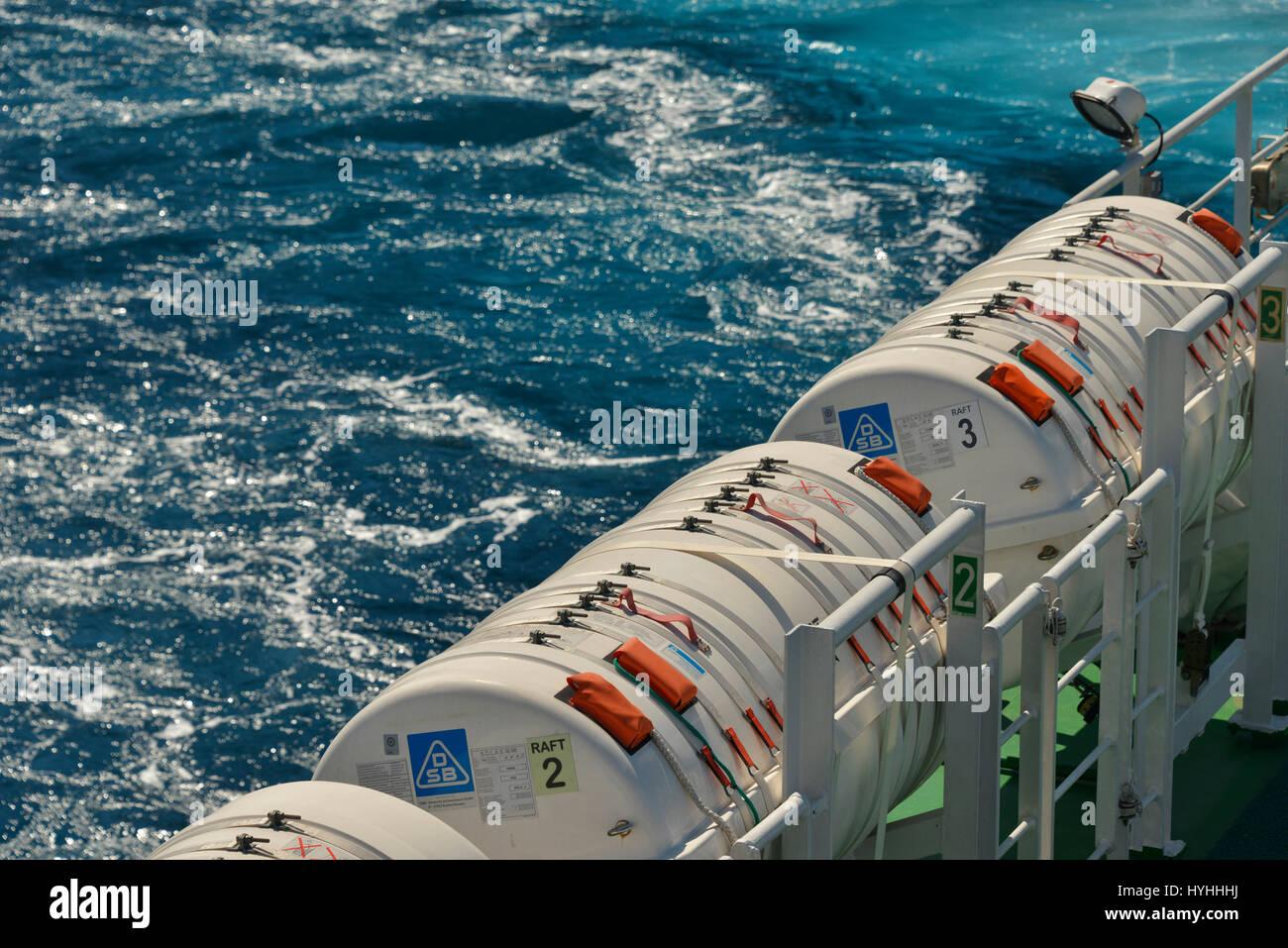 Close up of sealed life rafts on an inter-island ferry with ocean wake ...