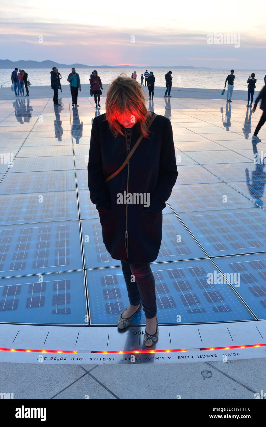 Portrait view of a woman with a red illuminated face, watching the ...