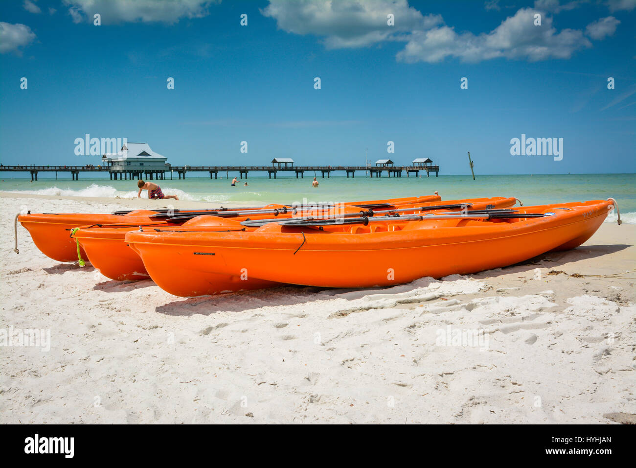 Orange Kayaks rest on the white sands of Clearwater Beach, FL, with ...