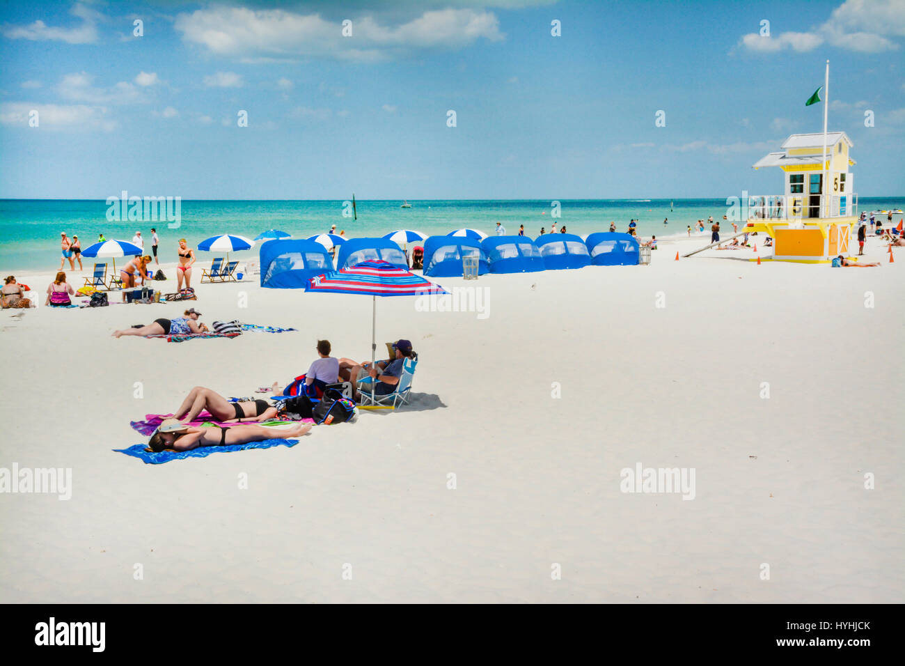 View of people enjoying the white sand and turquoise waters of ...