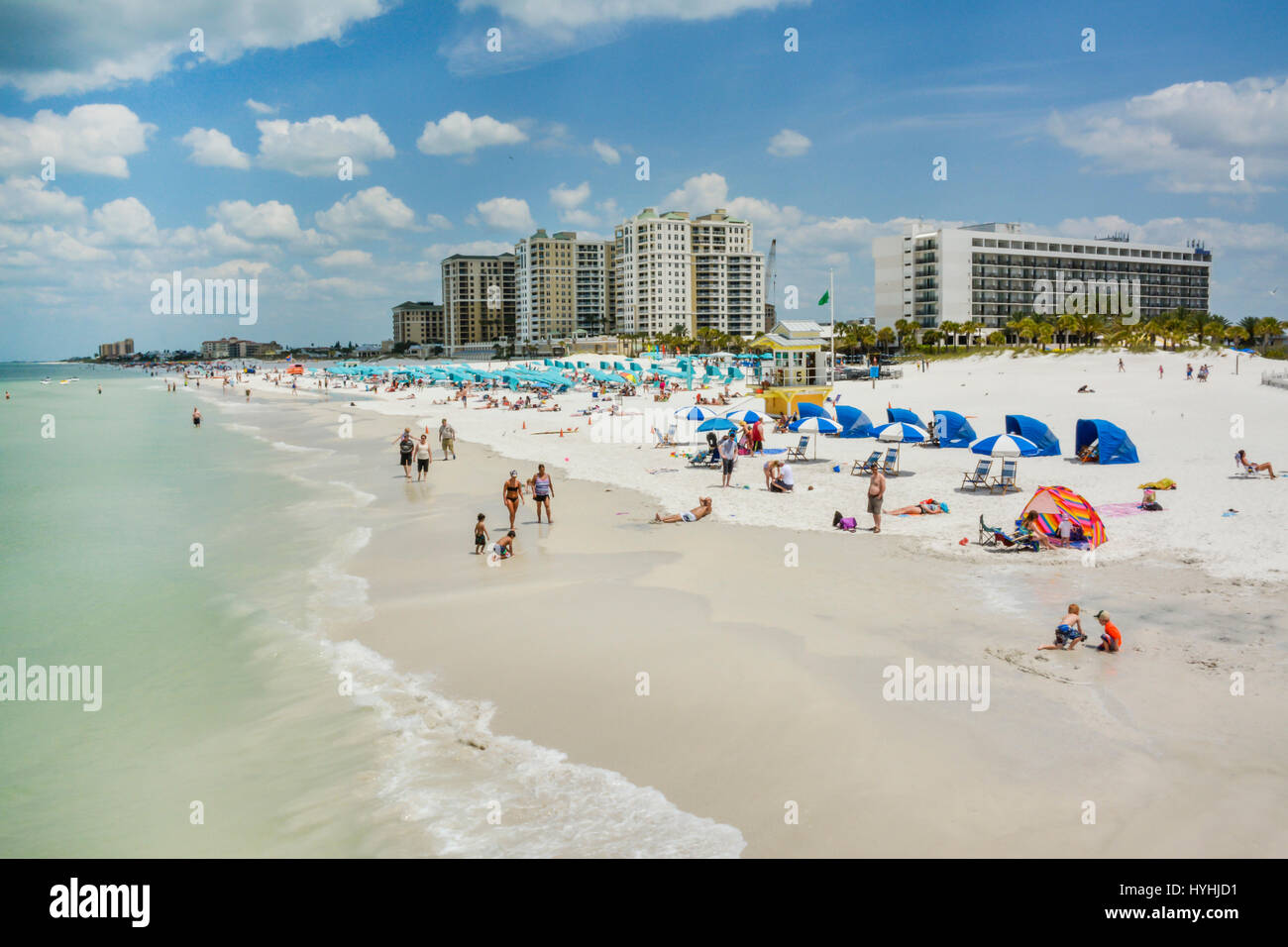 Long overview of people strolling, wading, swimming, sunbathing ...