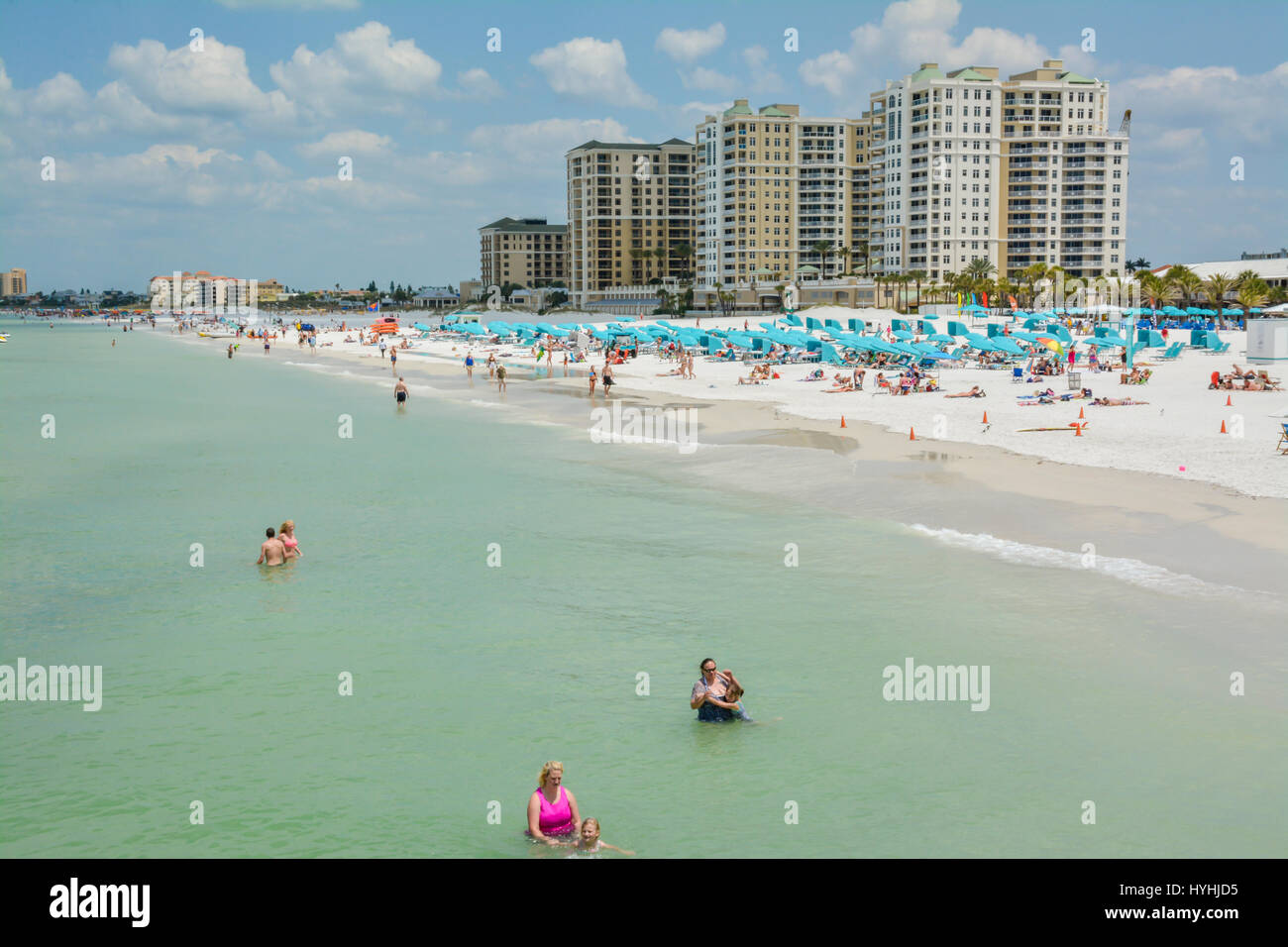 Long overview of people strolling, wading, swimming, sunbathing ...