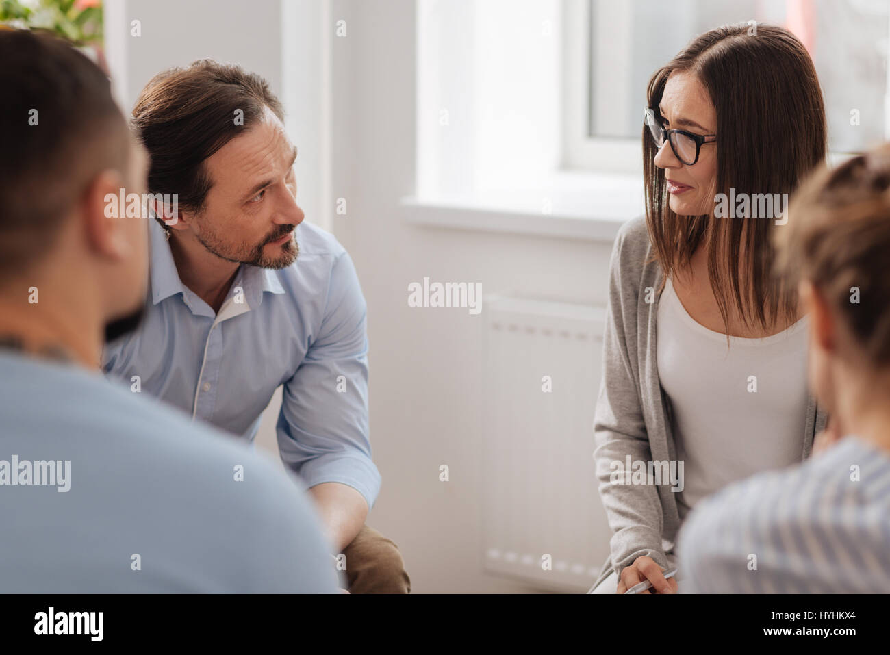 Positive delighted female sitting in semi position Stock Photo - Alamy
