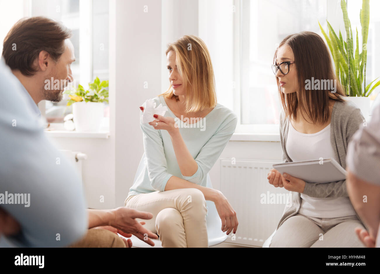 Two females looking at their colleague Stock Photo - Alamy