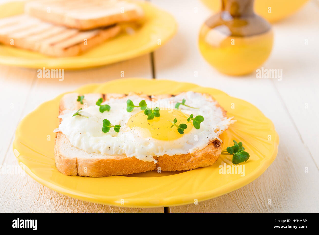 Toast with egg in yellow plate on white wooden background. Healthy ...