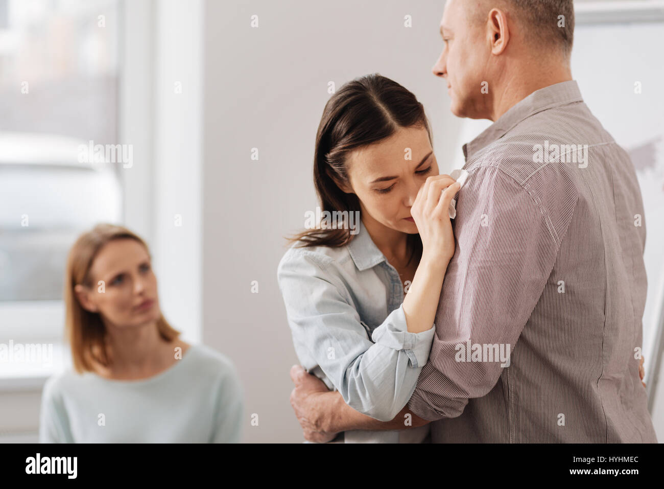 Portrait of upset brunette leaning on her colleague Stock Photo - Alamy