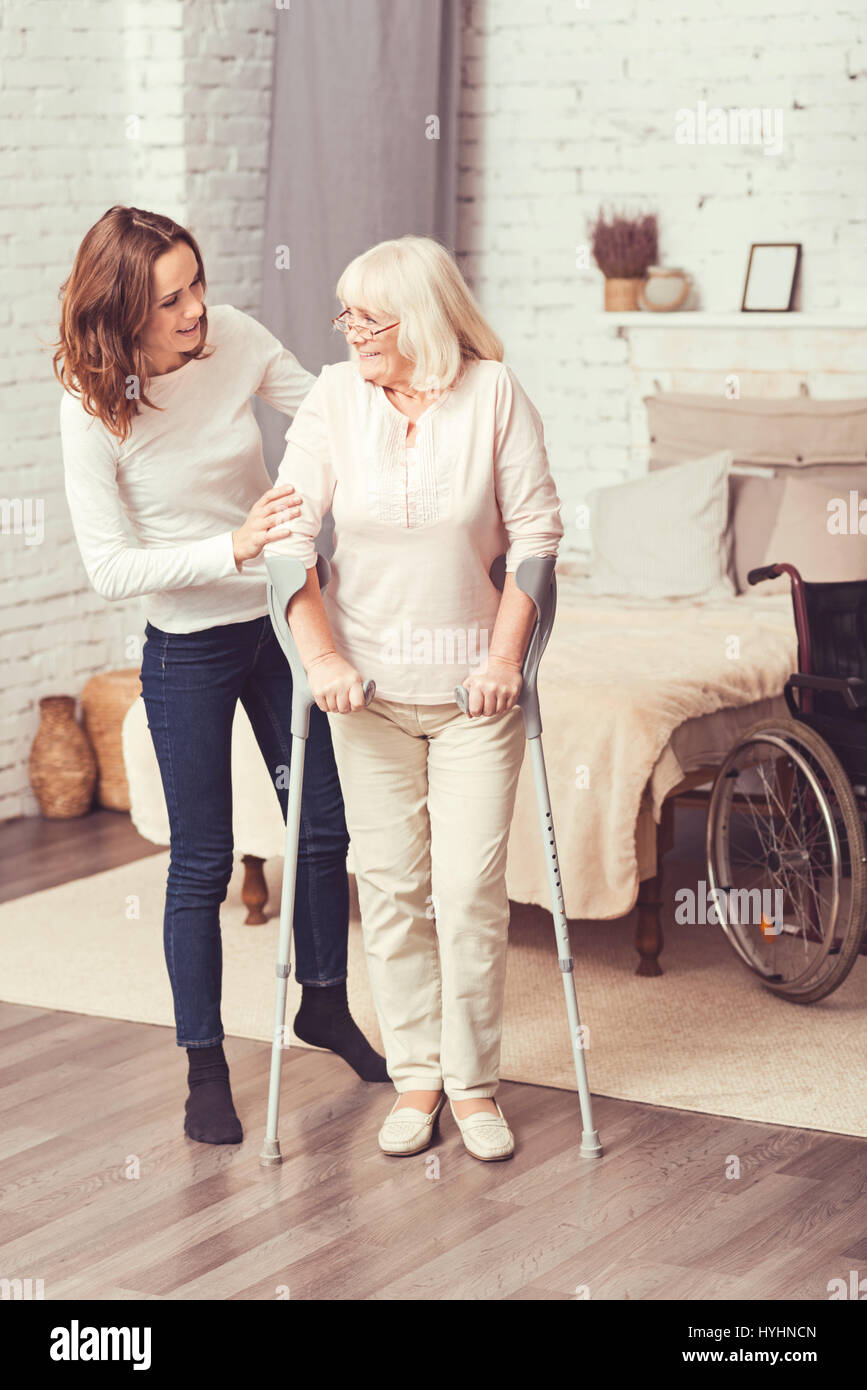 Helpful young woman helping disabled old mother at home Stock Photo - Alamy