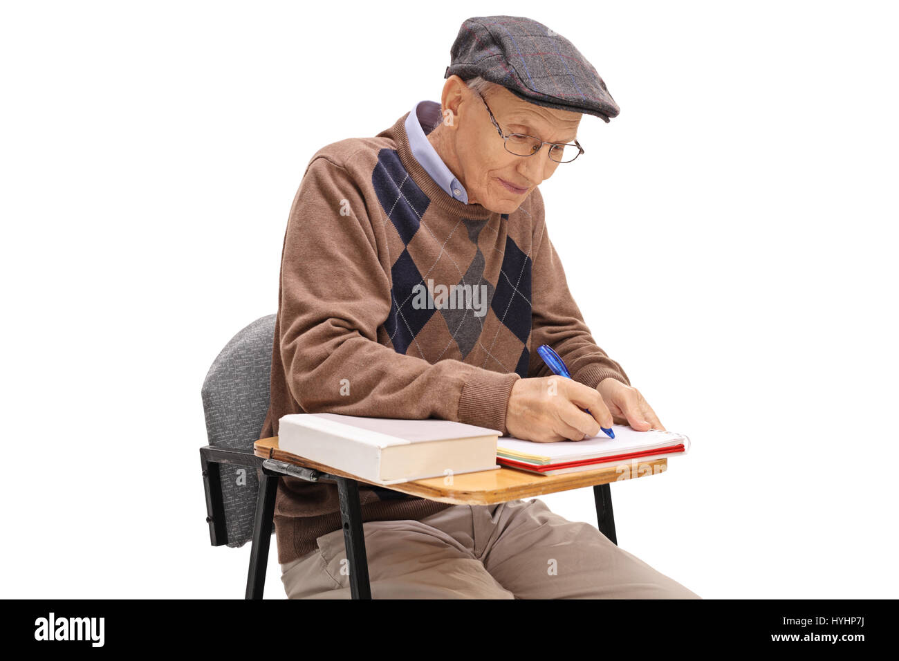 Elderly student sitting in a school chair and taking notes isolated on ...