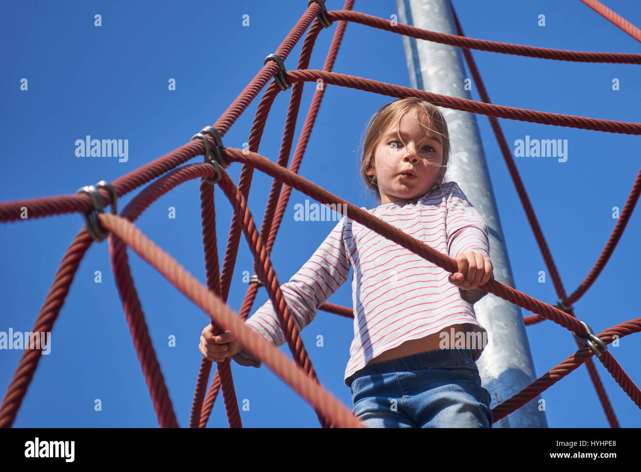 Active young child girl climbing the spider web playground activity ...