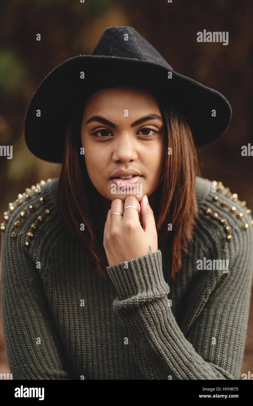 Young ethnic girl with hand on chin staring at camera Stock Photo - Alamy