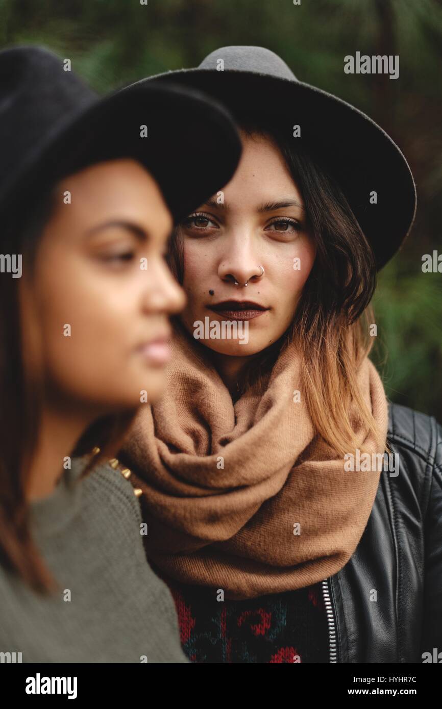 Young ethnic girls in hats modeling in front of trees Stock Photo - Alamy