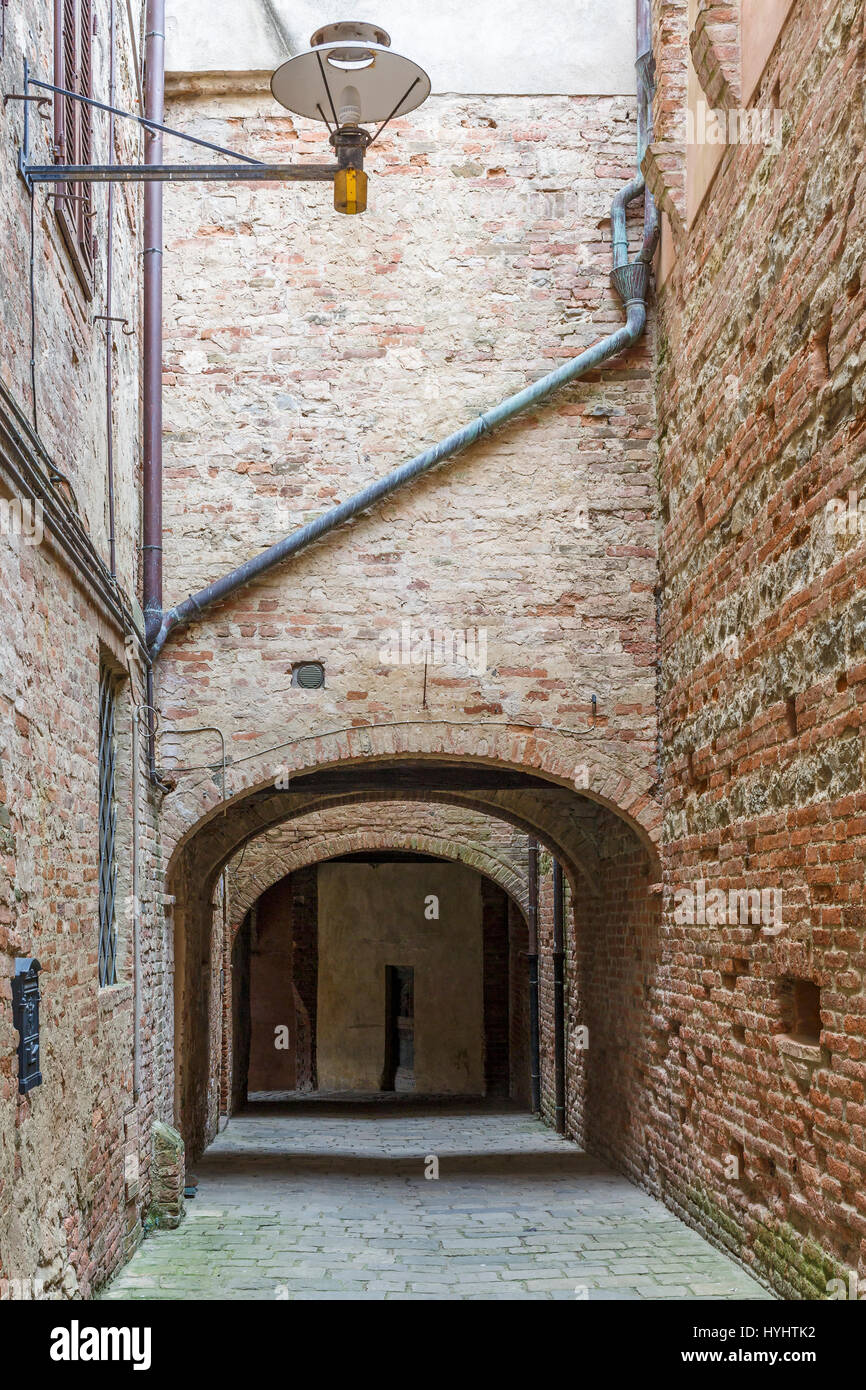 Dark alley with brick walls in an old Italian village Stock Photo - Alamy