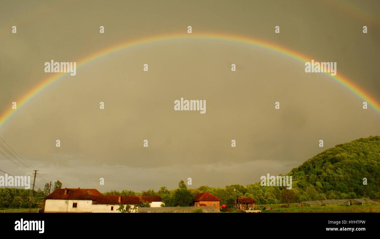 Rainbow Over Village Stock Photo - Alamy