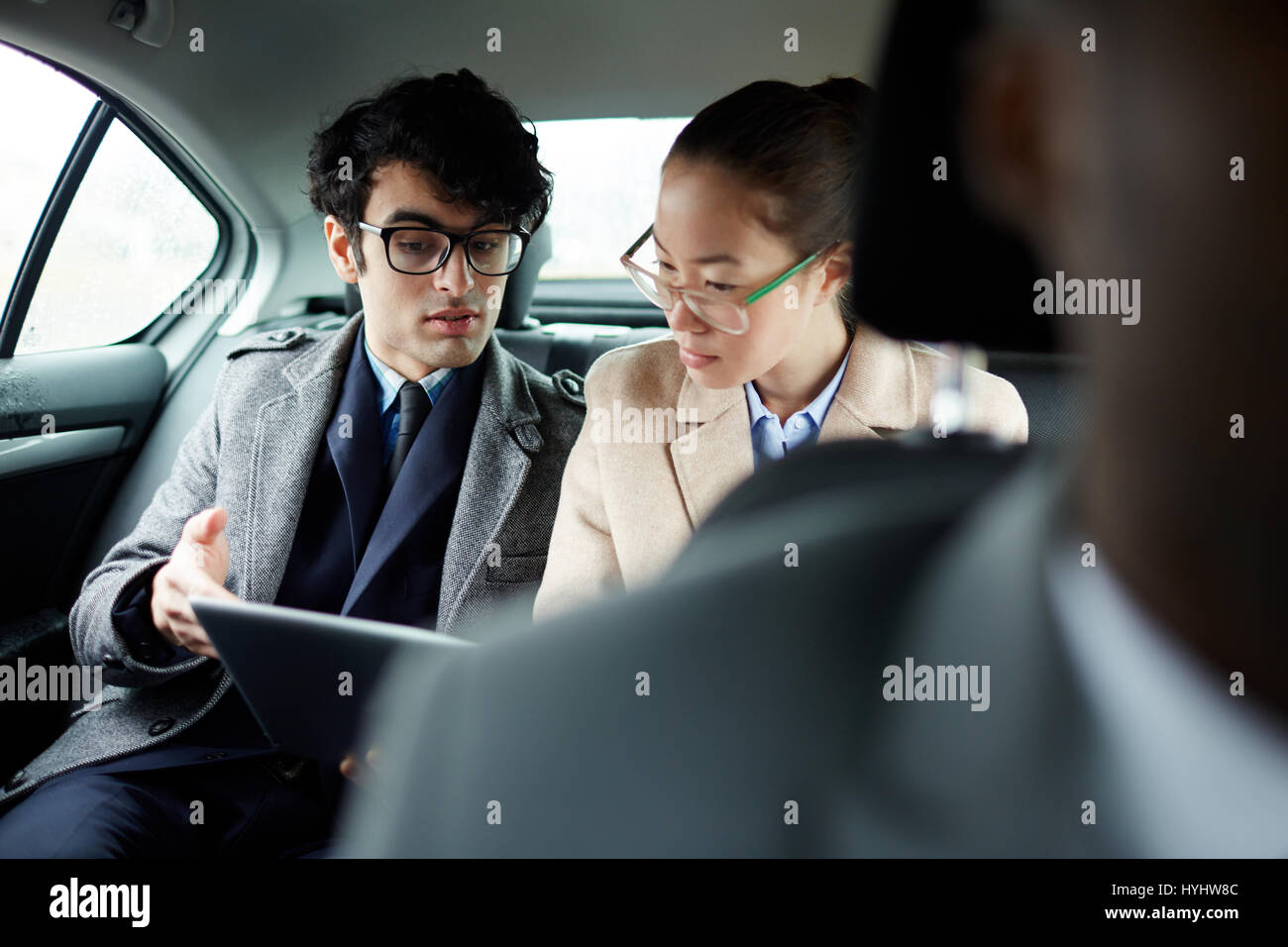 Business People Discussing Document in Car Stock Photo - Alamy