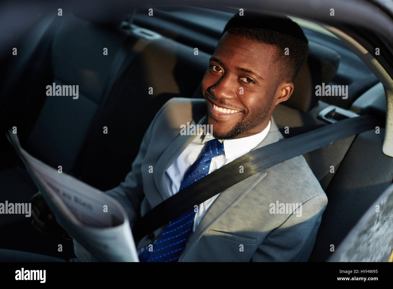 Smiling African Businessman Reading Newspaper in Car Stock Photo - Alamy